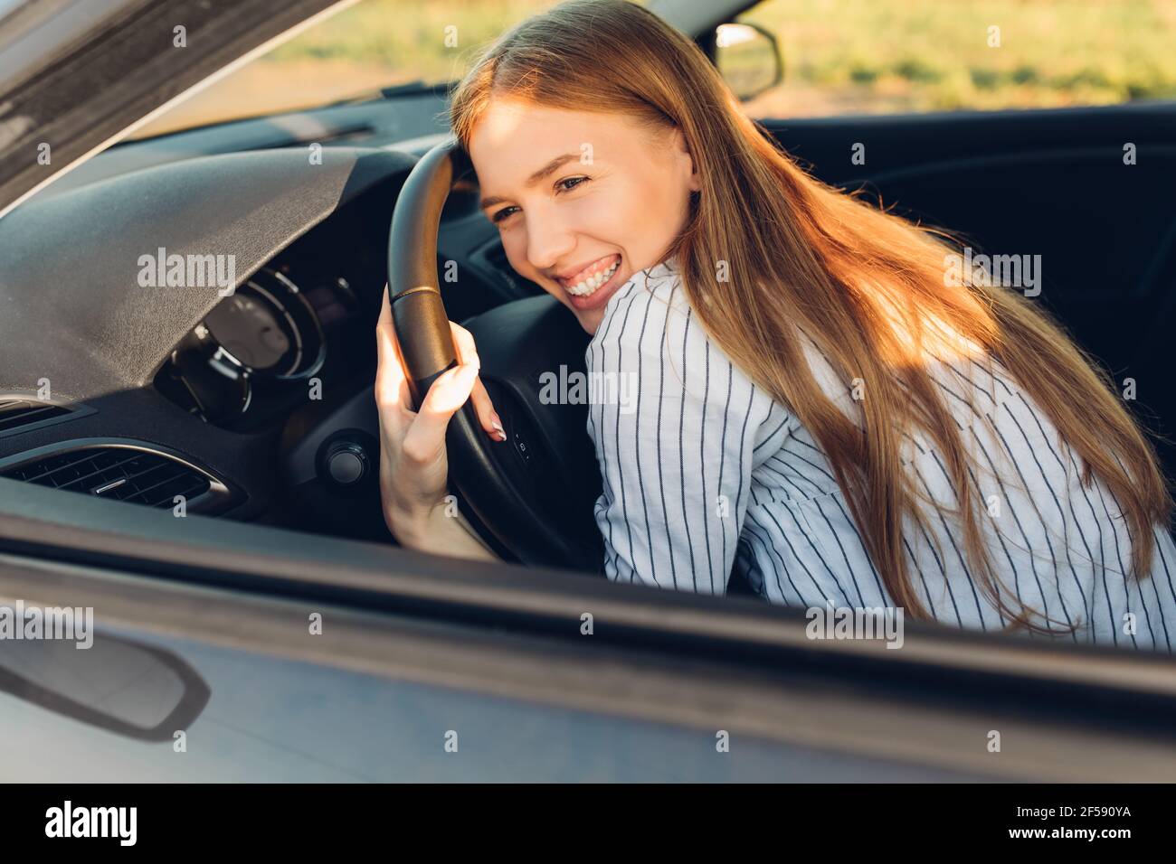 Young happy woman buys a car, Lady in a car salon, Elegant rejoicing ...
