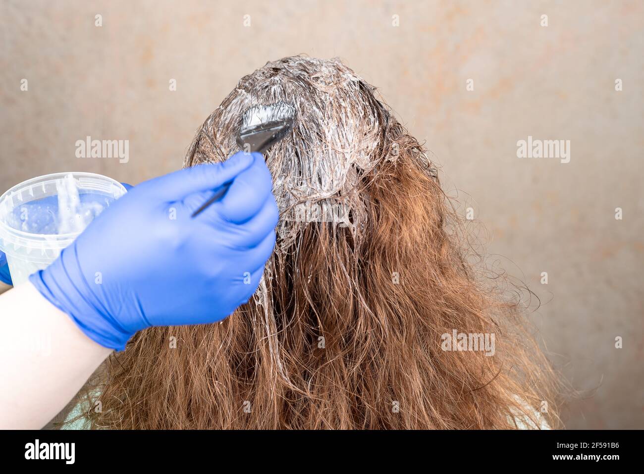 Soft focus drawing paint on female hair. Focus on the model's head ...