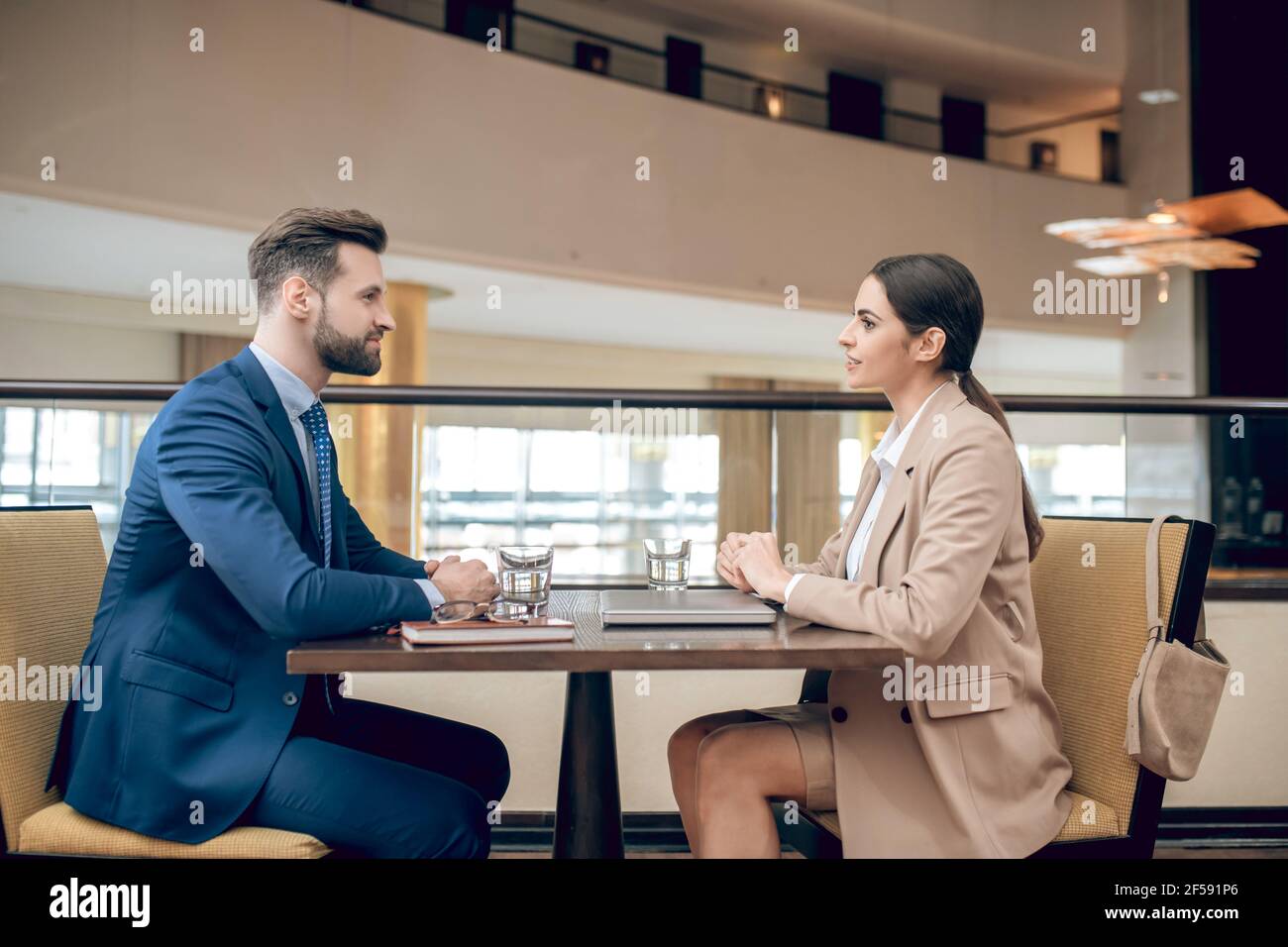 Young woman in a beige suit having an interview with a manager Stock ...
