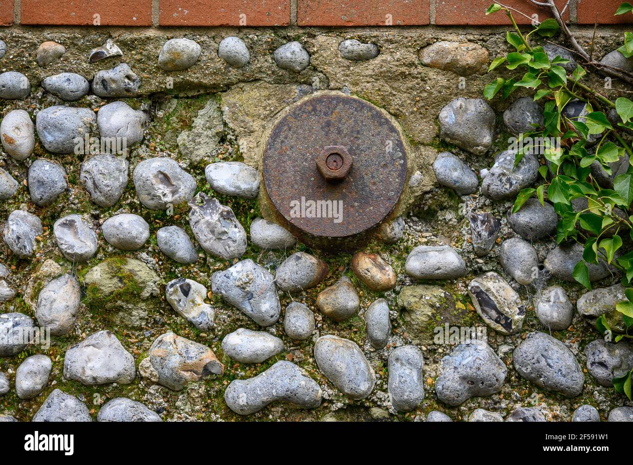 Detail of a flint wall with brick top, and an anchor plate Stock Photo ...