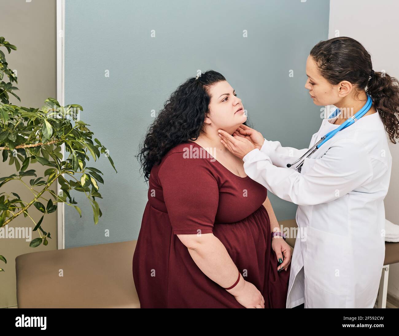 doctor palpation of fat woman's neck for diagnostics of thyroid ...