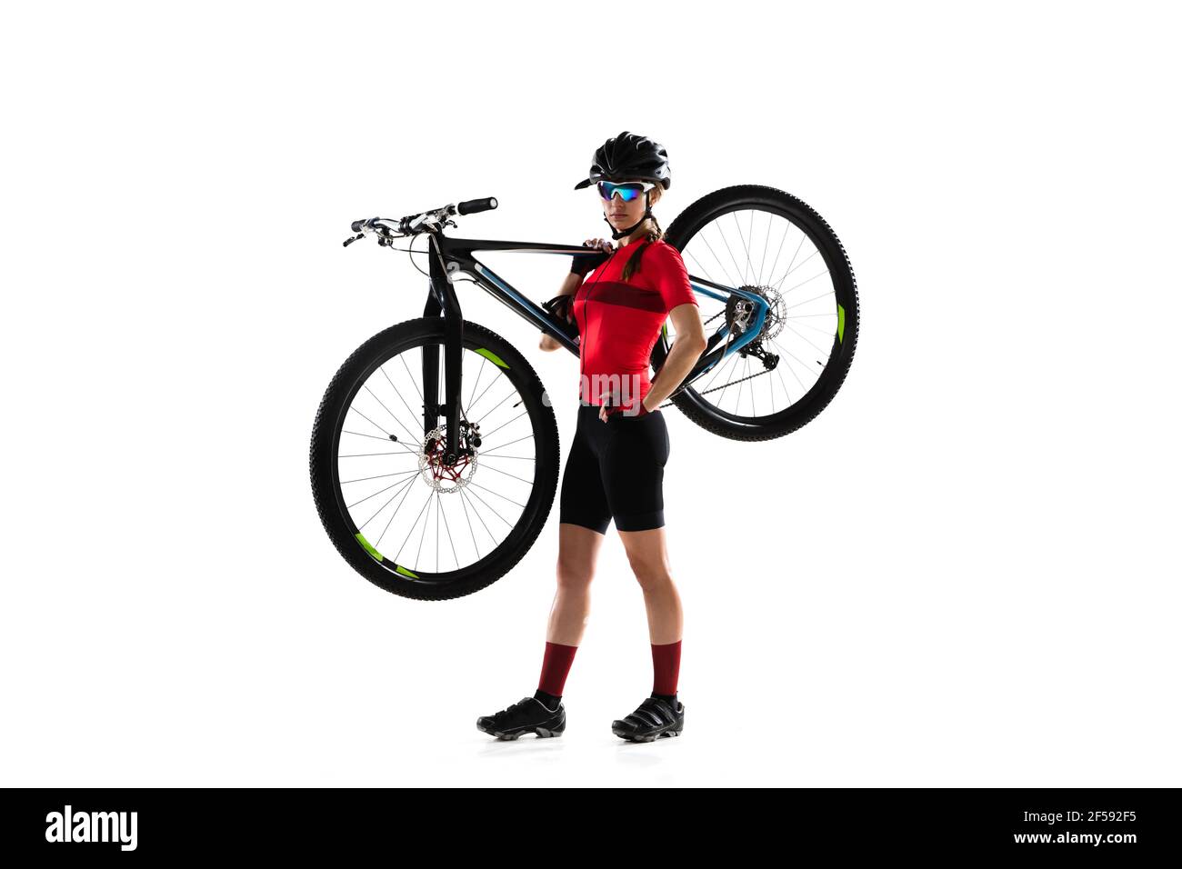 Caucasian professional female cyclist with bike isolated over white ...