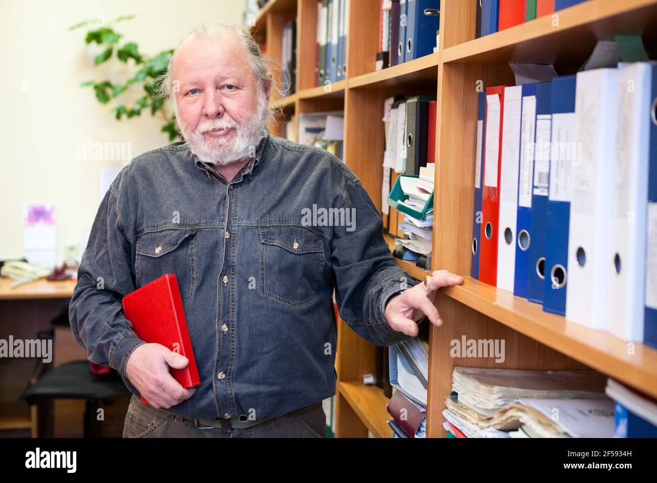 Senior academic professor or teacher with lot of documents, knowledge ...