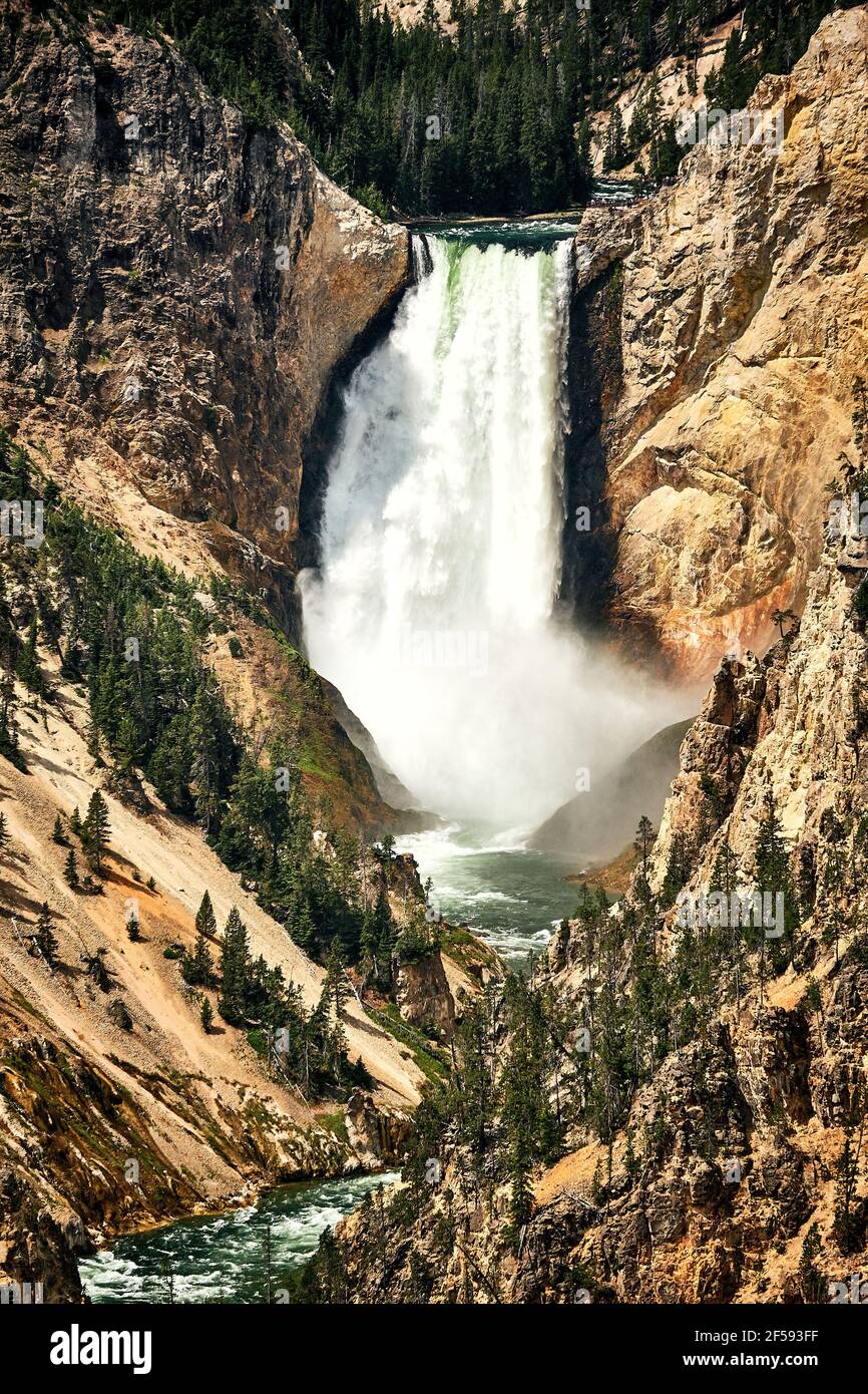 Vertical shot of a waterfall surrounded by rocky hills in the ...