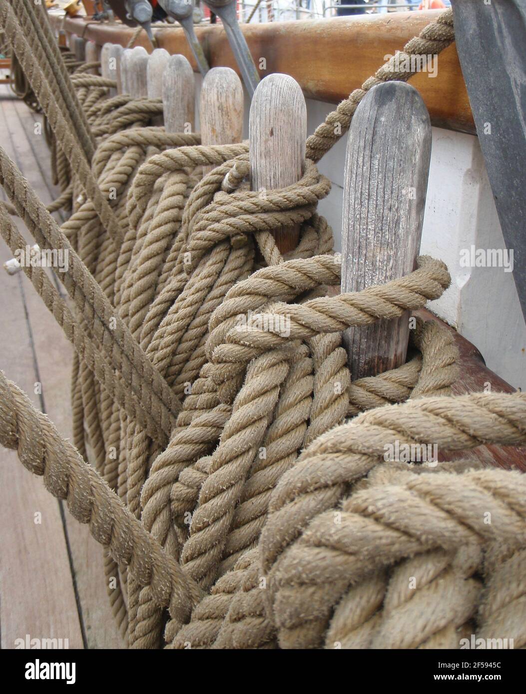 Belay pins with rope coils on a square rig sailing boat Stock Photo - Alamy