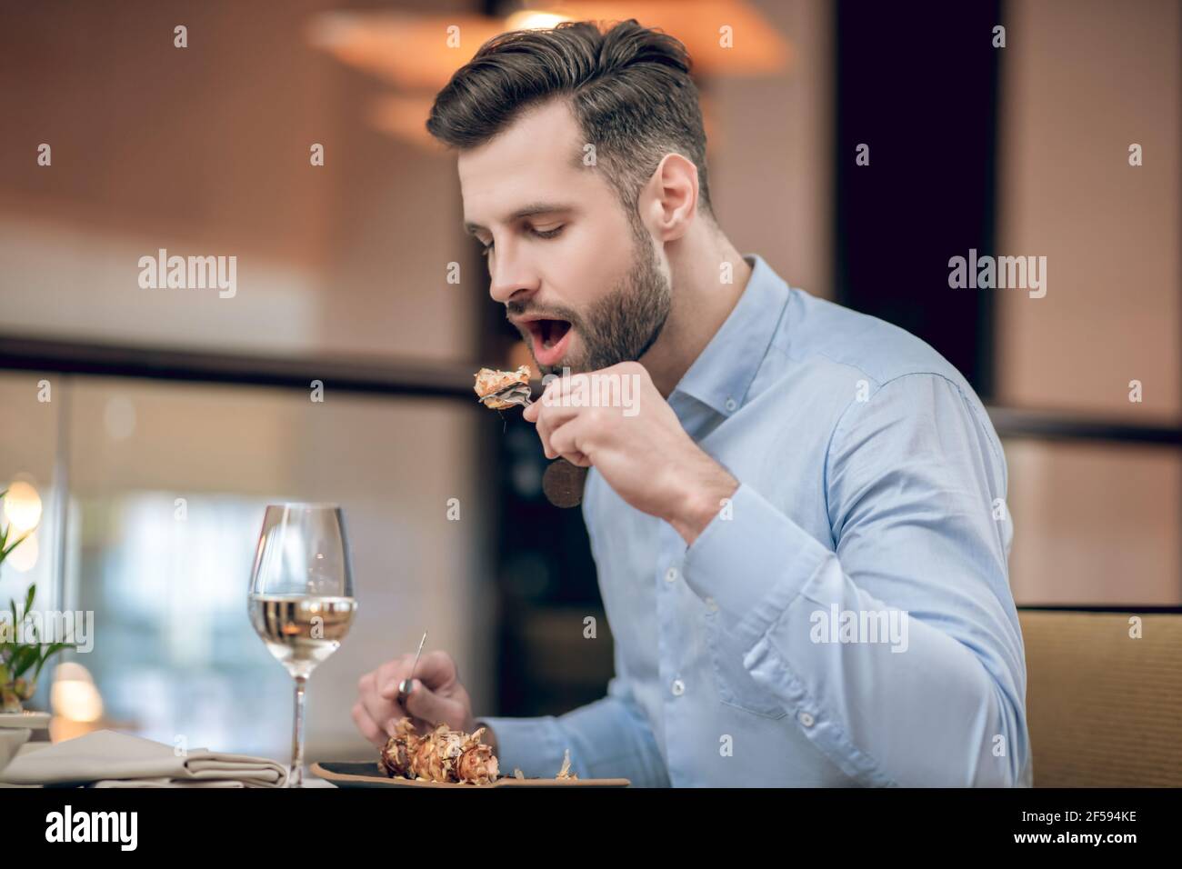 Man eating seafood at the restaurant and looking involved Stock Photo ...