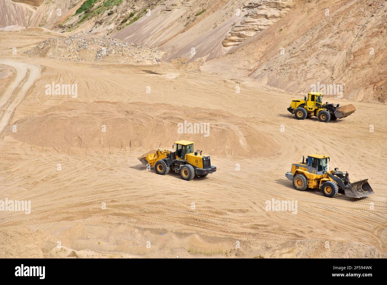Wheel front-end loaders working at the sand open pit. Quarry in which ...