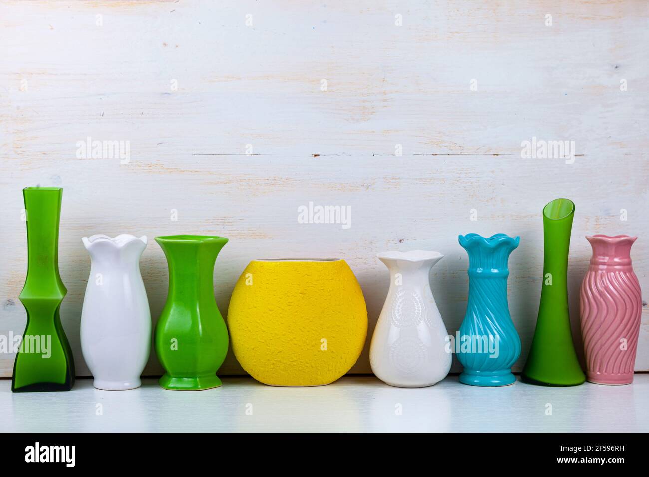 Eight multi-colored flower vases on a white wooden background Stock ...