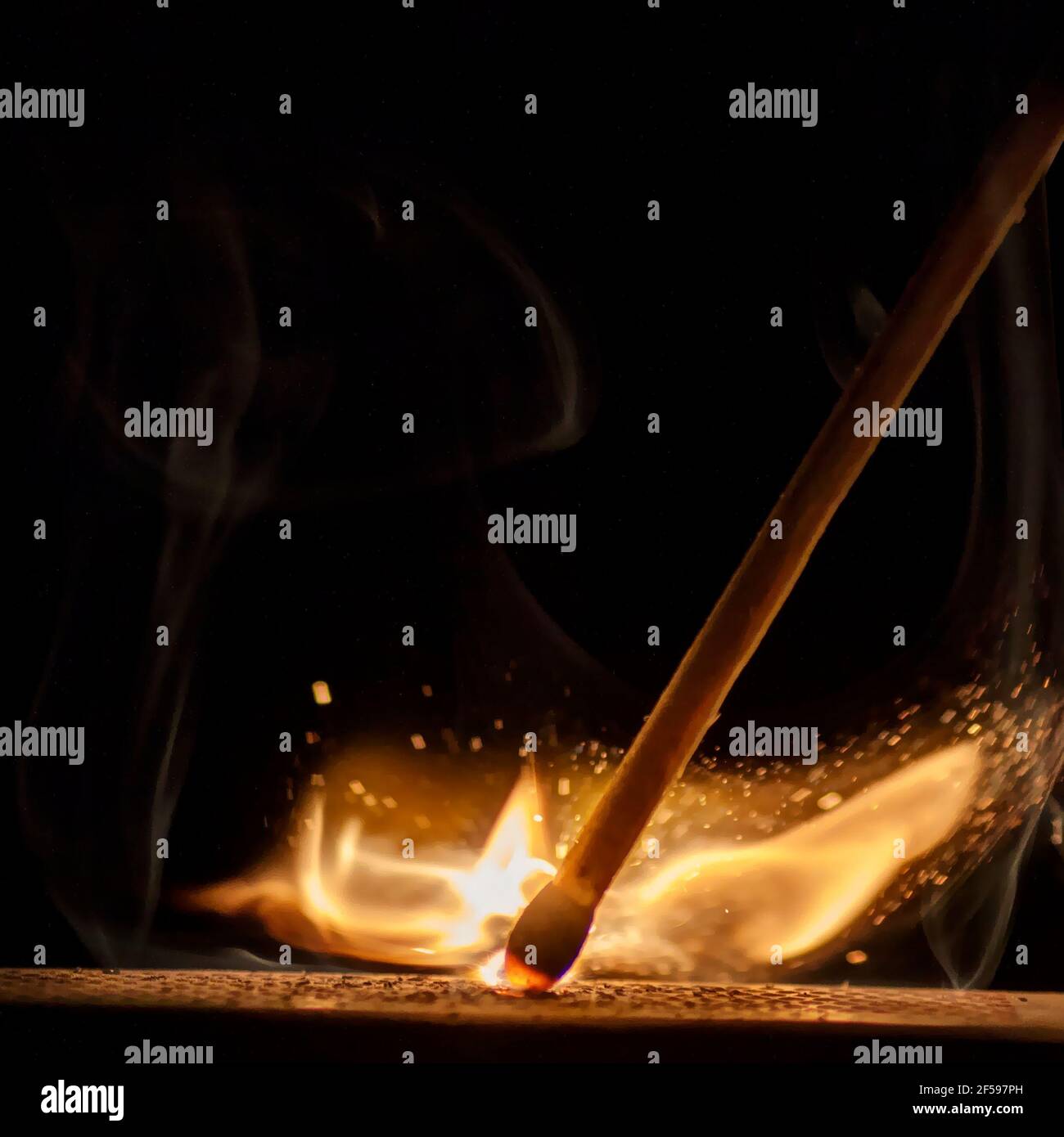 Striking match sourrounded by sparks Stock Photo - Alamy