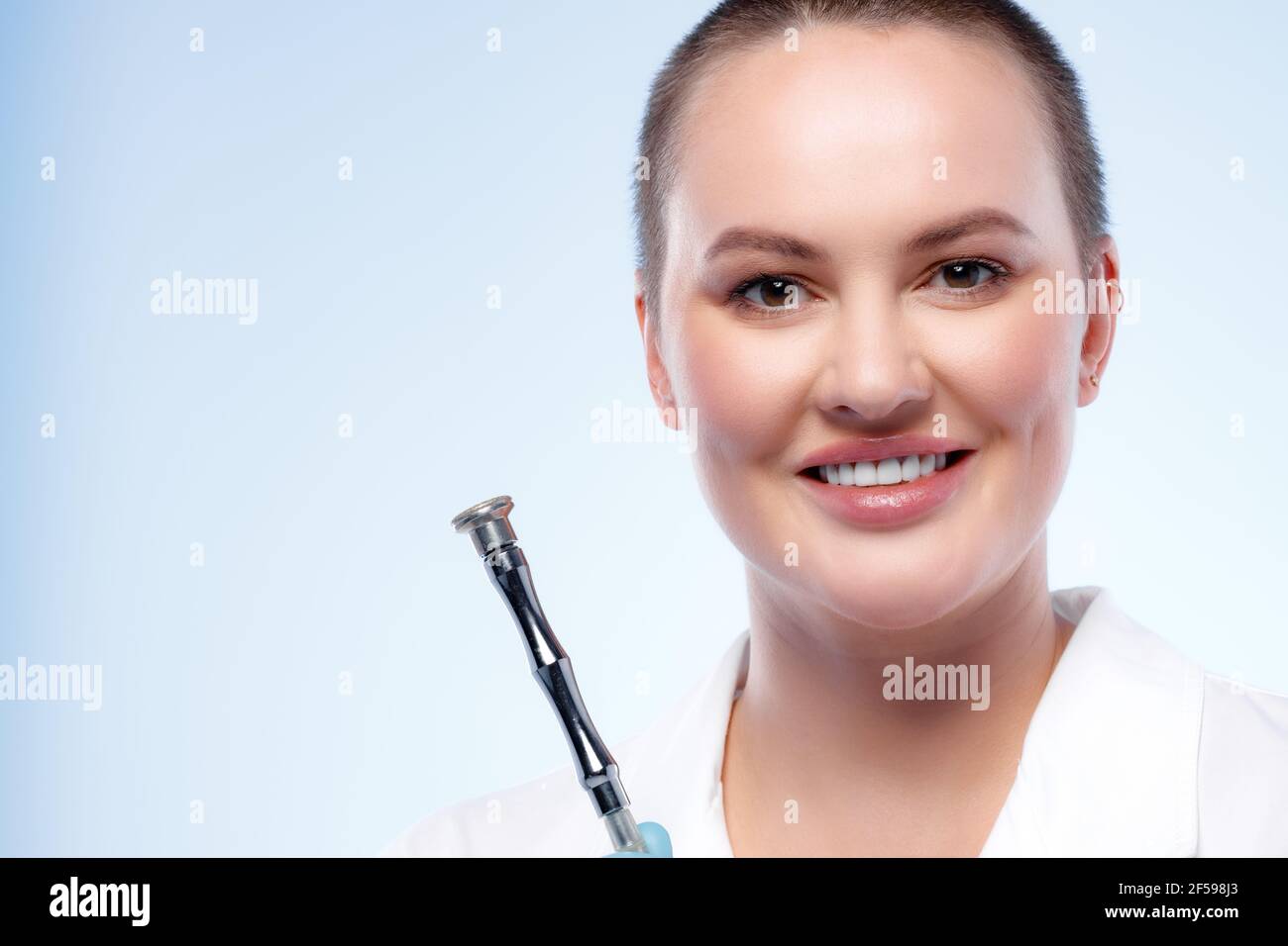 Portrait of a woman dermatologist holding cosmetic device attachment ...