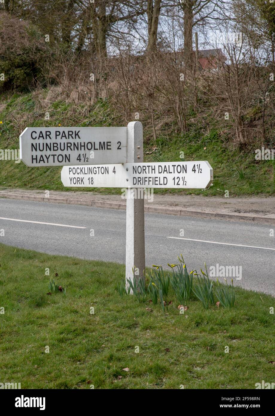 A white wooden signpost with directions to a car park and six towns in ...