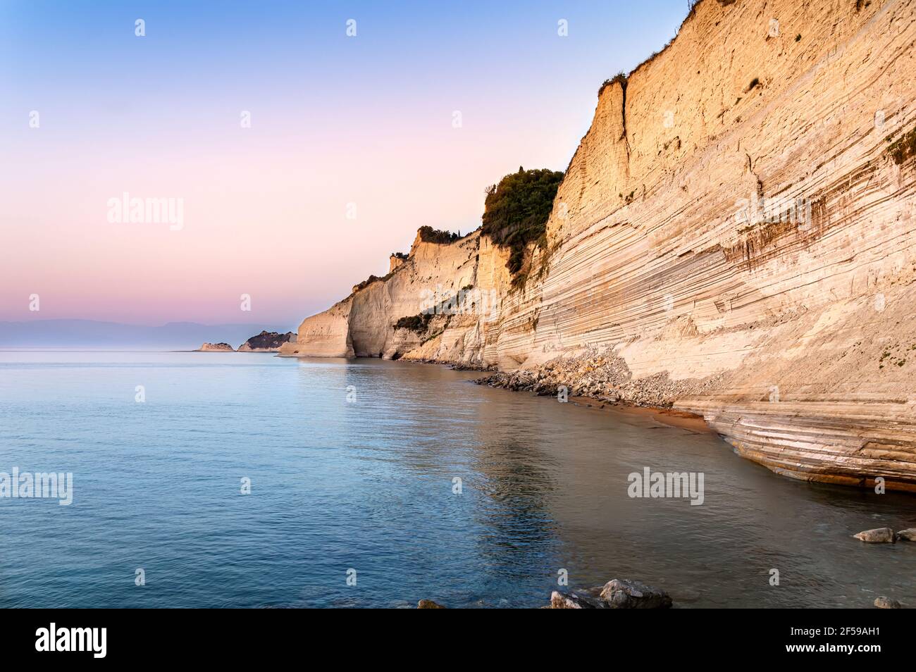 Logas sunset beach with sheer white cliffs in Peroulades village on ...
