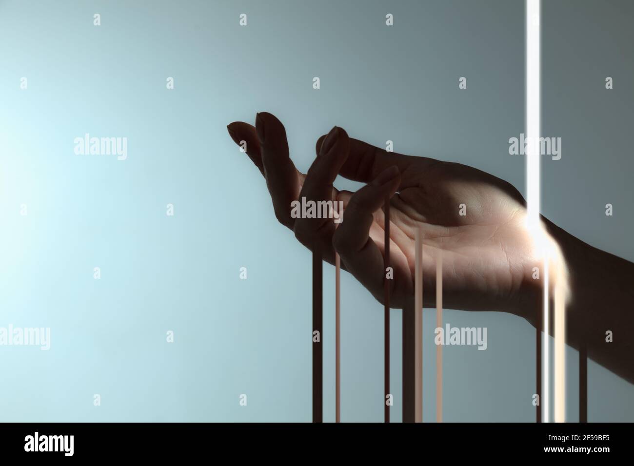 Beautiful female hand catching streaks of light isolated on grey ...