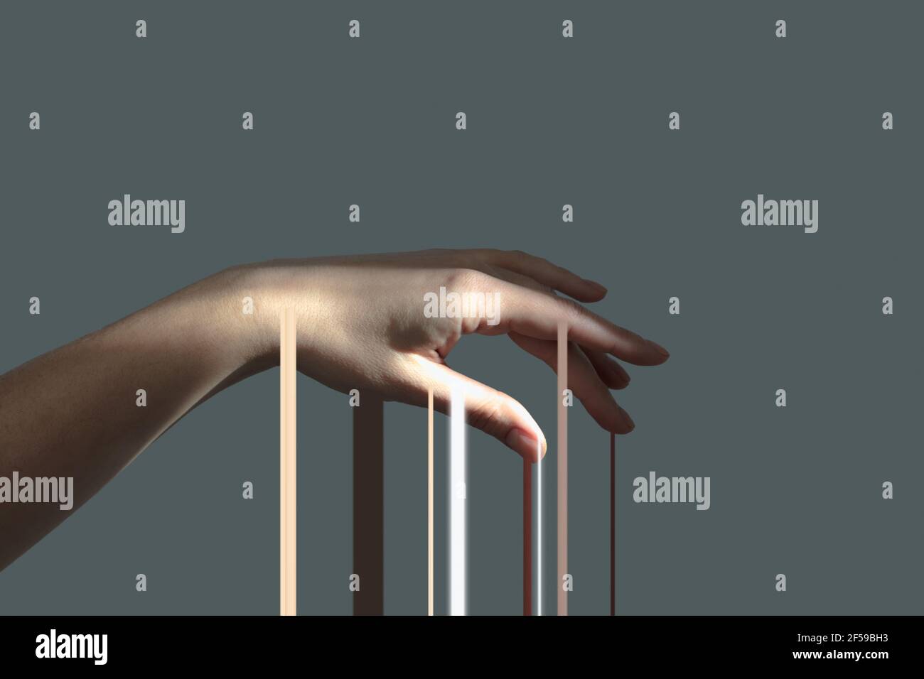 Streaks of light trickle down of soft female hand isolated on grey ...