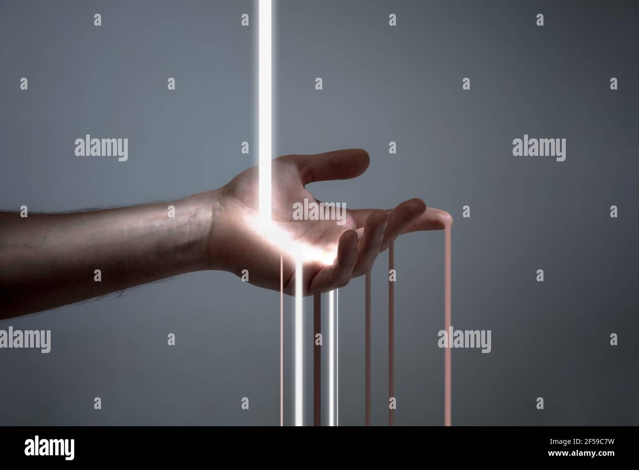 Light rays passing through delicate female hand isolated over grey ...