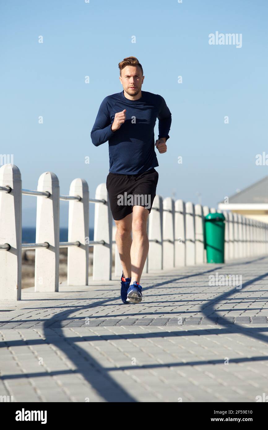 Full body portrait of active young man running outside Stock Photo - Alamy