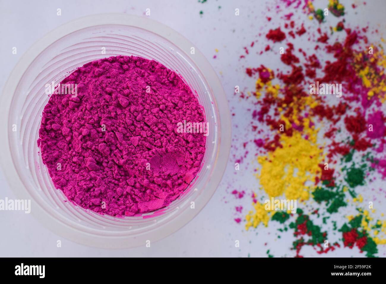 Holi colours powder scattered on white background with Pink or Gulabi ...