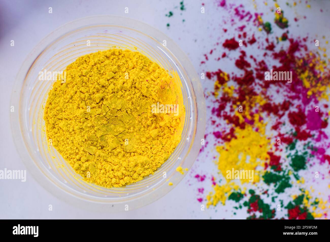 Holi colours powder scattered on white background with Yellow or peela ...