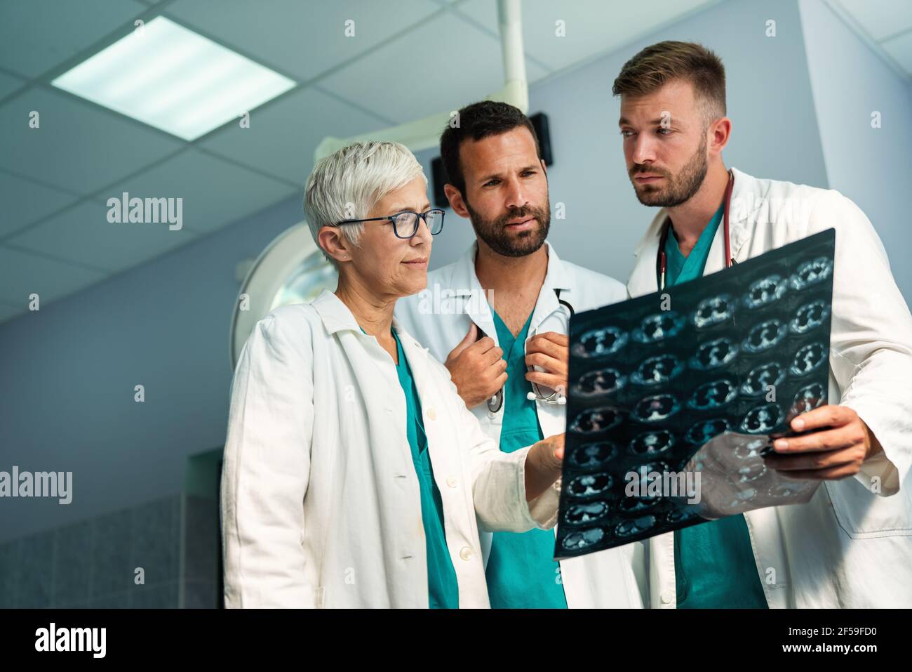 Group of radiology doctor looking at x-ray and discussing it Stock ...