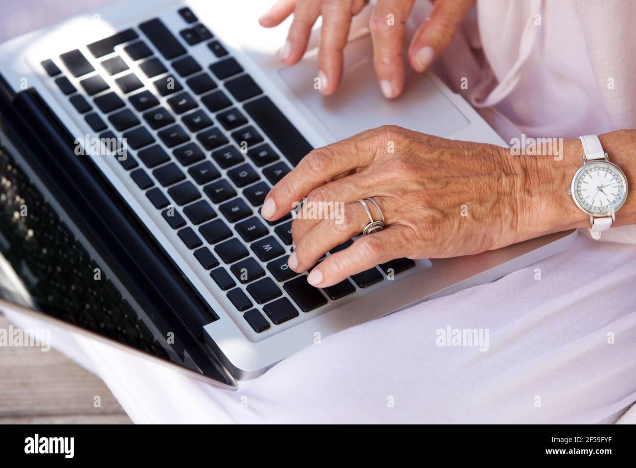 Close up portrait of older woman typing on laptop computer Stock Photo ...