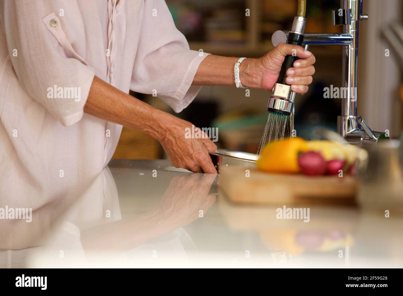Elderly woman washing up at the kitchen sink hi-res stock photography ...