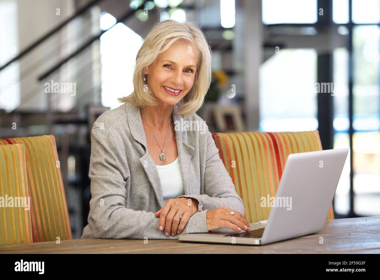 Portrait of beautiful older woman working laptop computer inside Stock ...