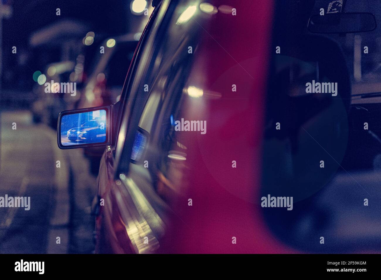 Police car with blue lights reflected in the rearview mirror of a ...
