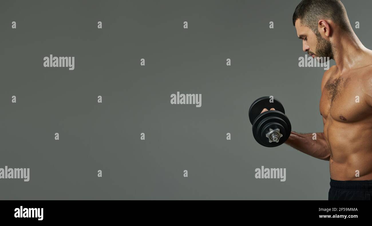 Website header of Adorable athlete man toning muscles in room indoors ...