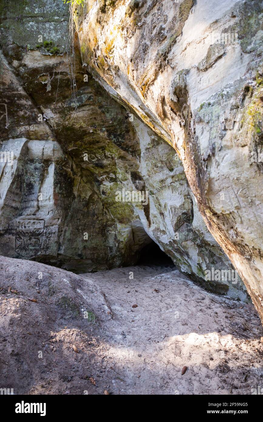 sandstone rock wall and entrance to the cave, the cave is located on ...