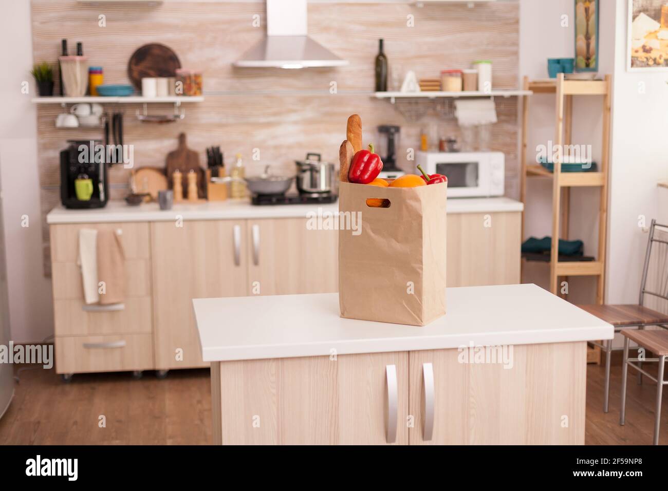 Paper bag filled with groceries on kitchen table top. Fresh and healthy ...
