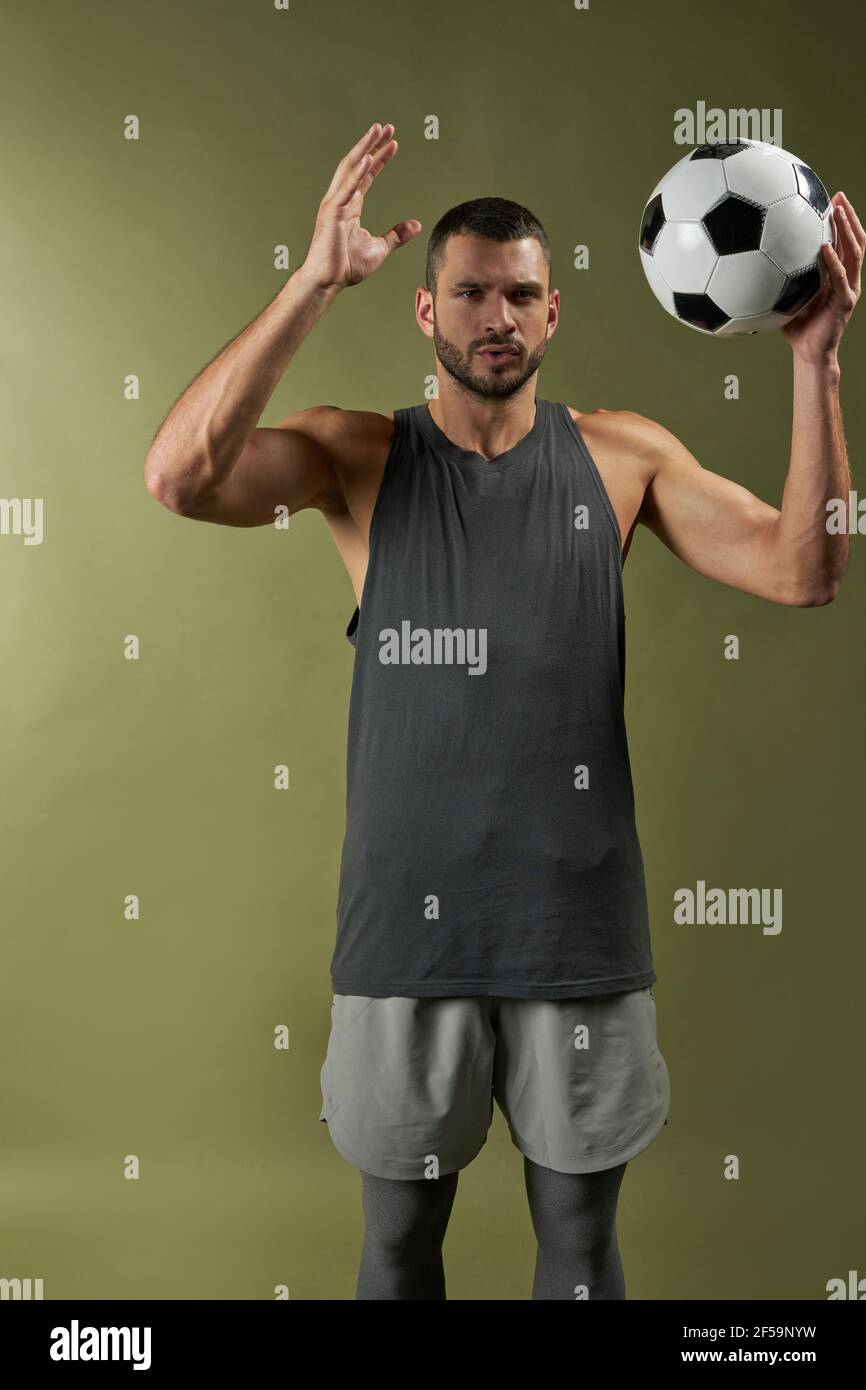 Adult Caucasian handsome football trainer in action with ball in the ...