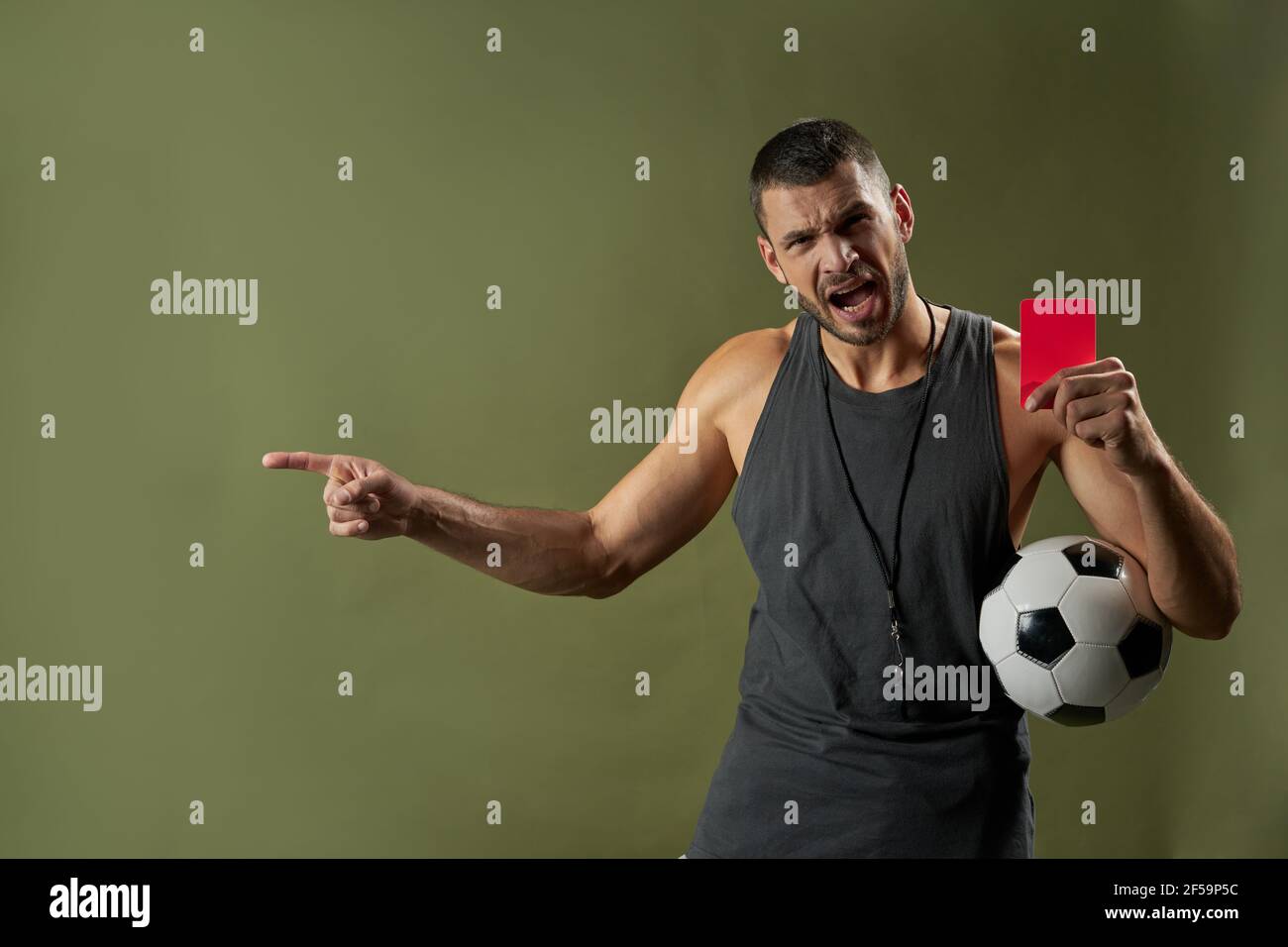 Angry football referee in grey sportswear holding red card in arm ...