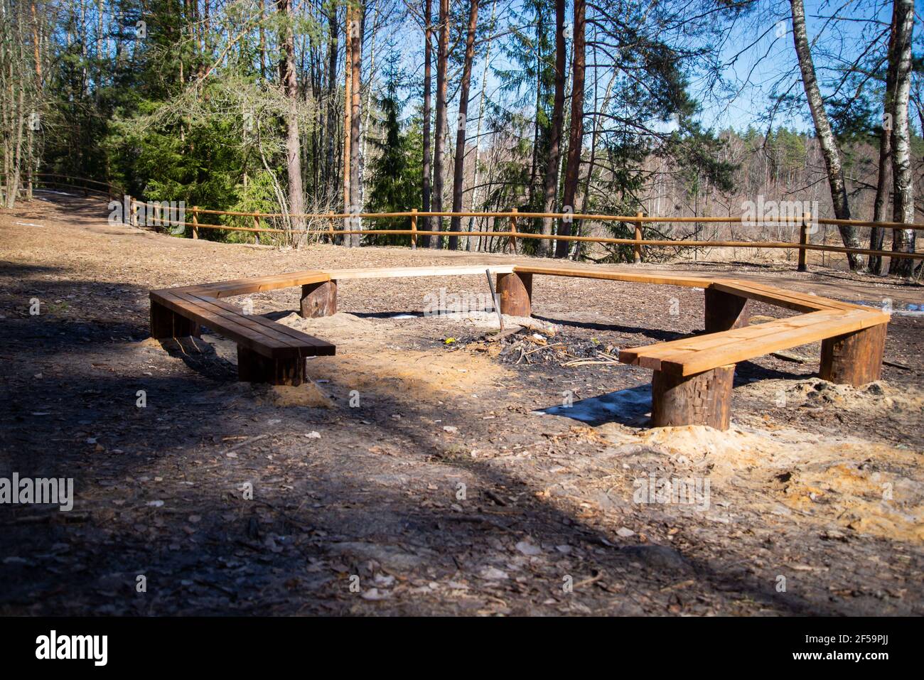 fireplace in the camping place with wooden troughs for rest. surrounded ...