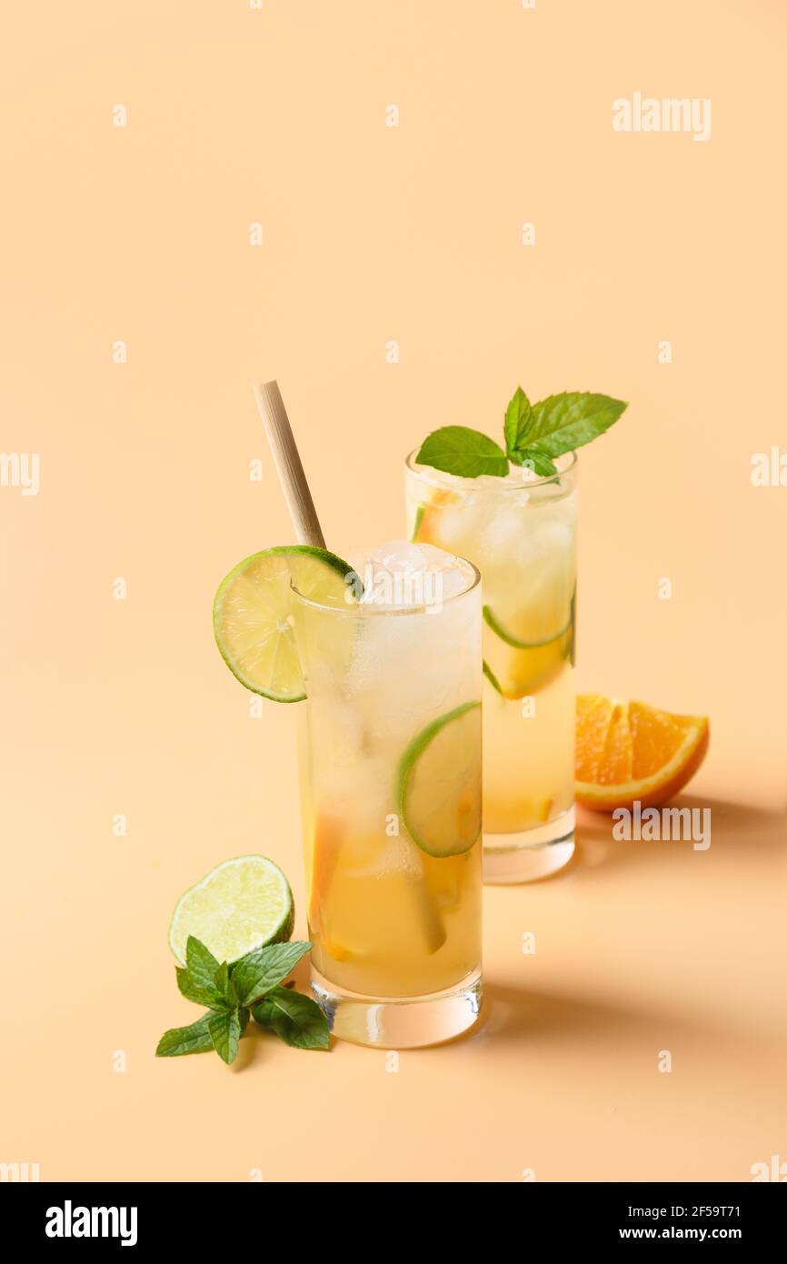 Cold and refreshing lemonade or cocktail with orange and lime slice on ...