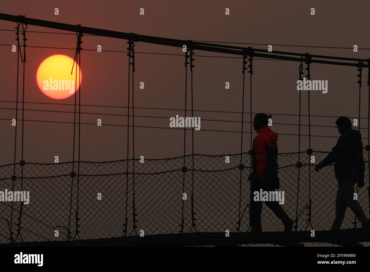 March 25, 2021, Kathmandu, NE, Nepal: People cross a suspension bridge ...