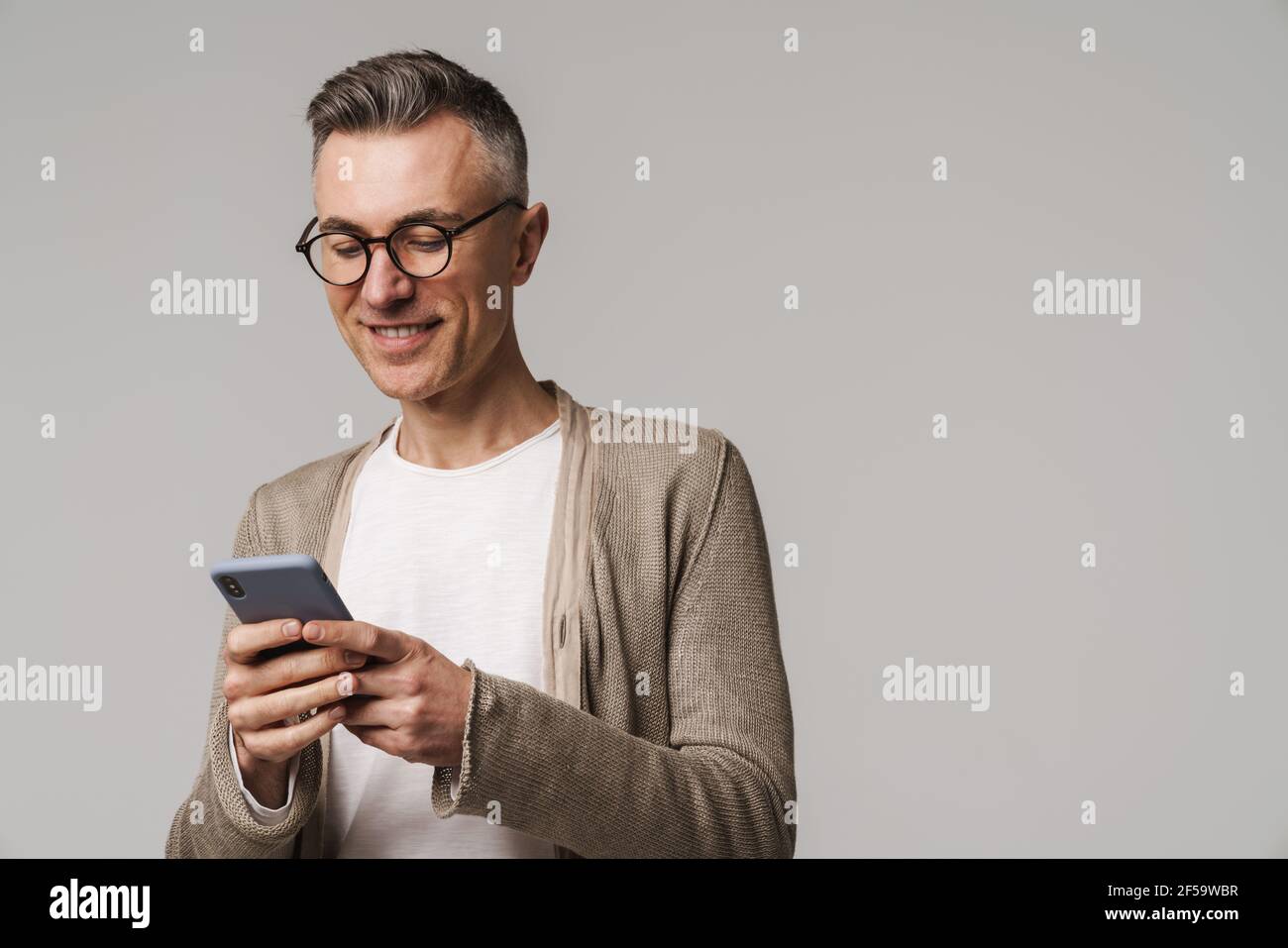 Smiling attractive smart looking man using mobile phone isolated on ...