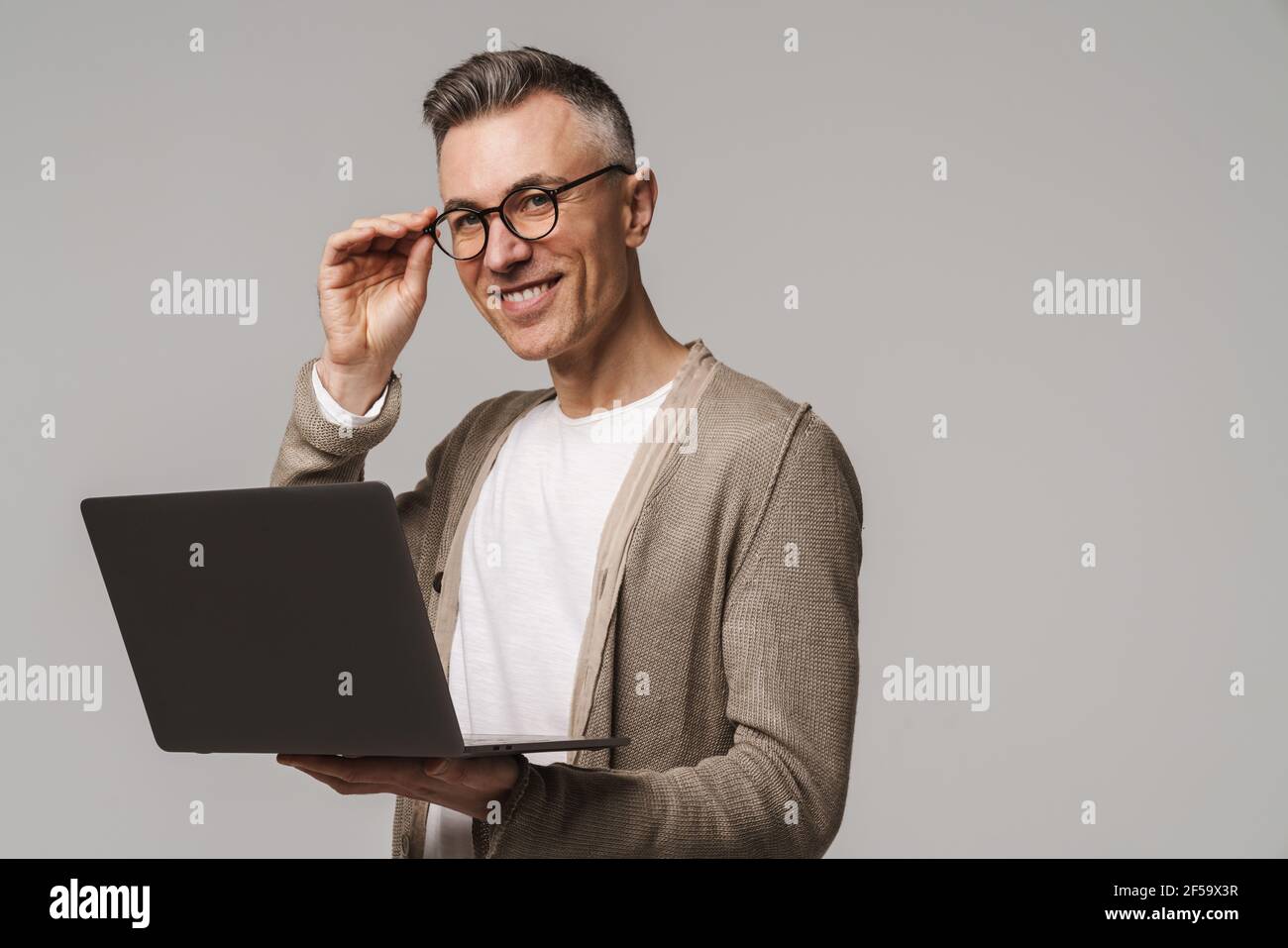 Confident smiling handsome smart looking man standing with laptop ...