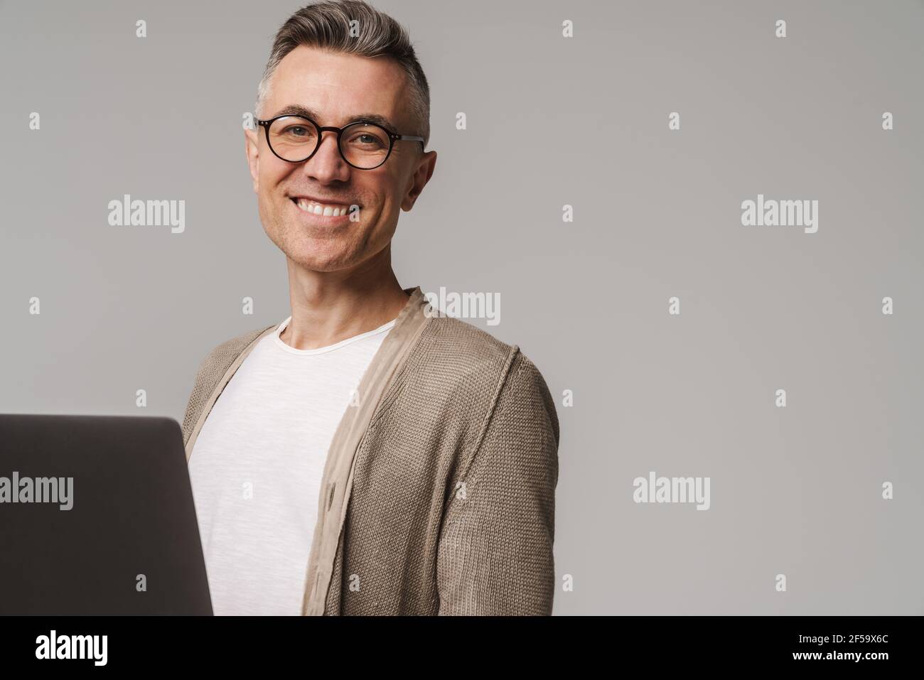 Confident smiling handsome smart looking man standing with laptop ...