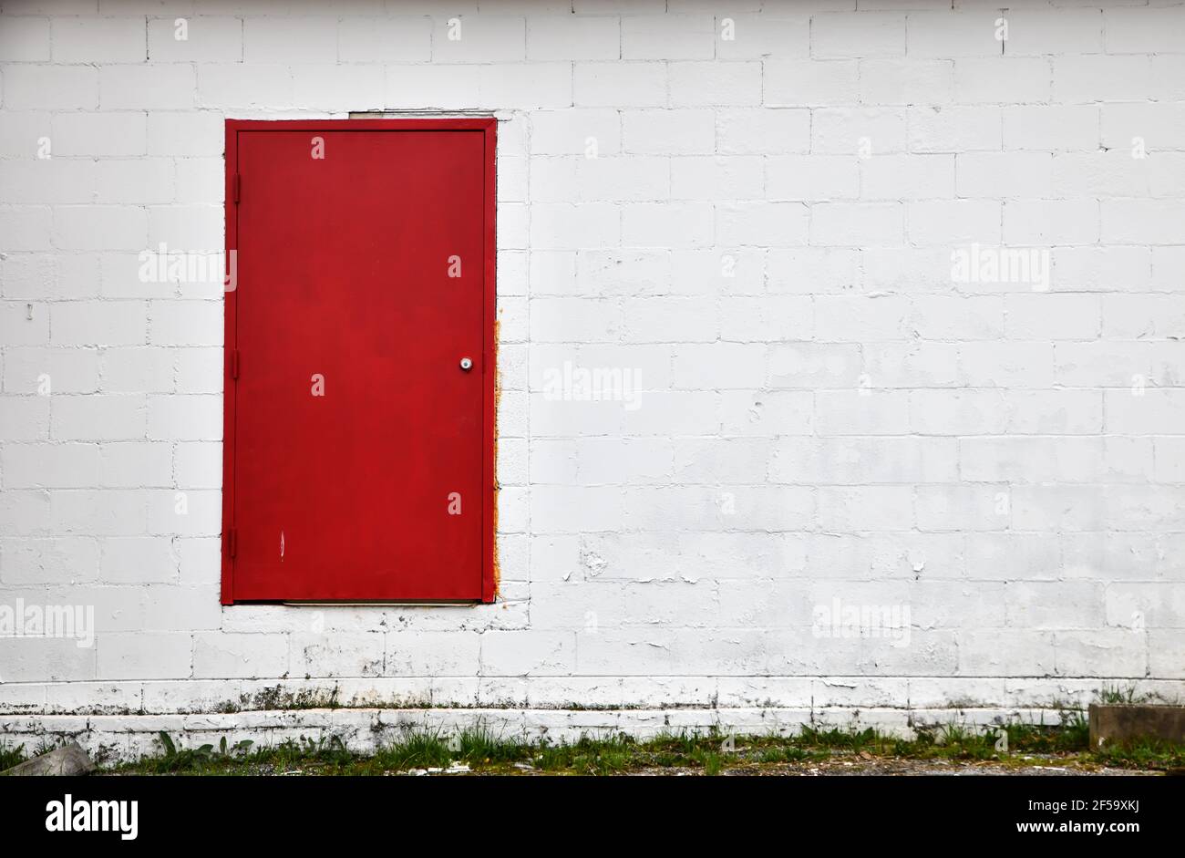 Closed red door on white brick building wall Stock Photo - Alamy