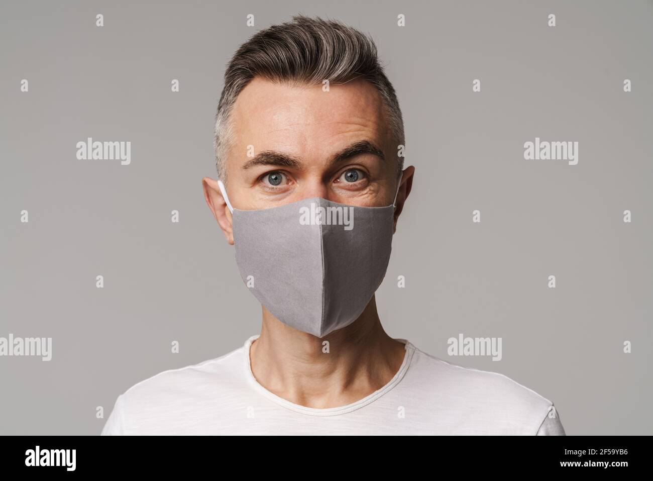 Close up of a confident man in protective medical mask isolated over ...