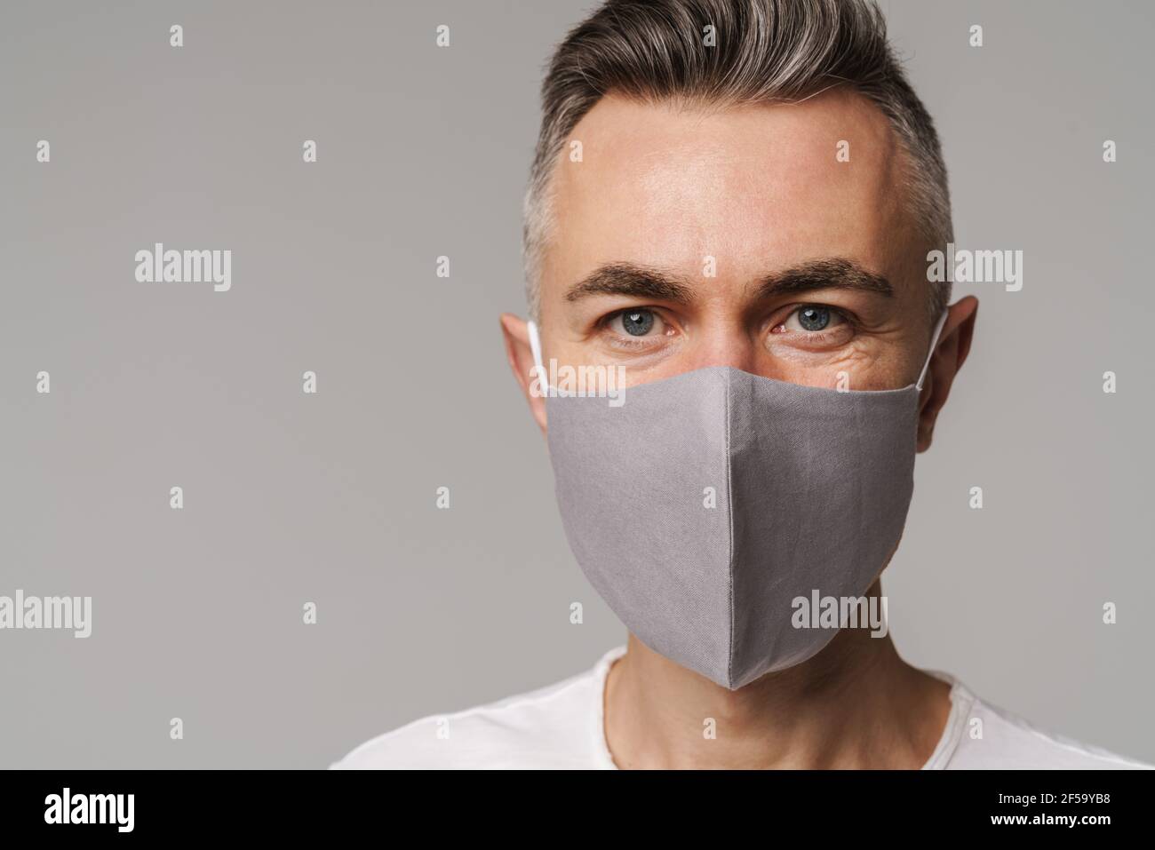 Close up of a confident man in protective medical mask isolated over ...