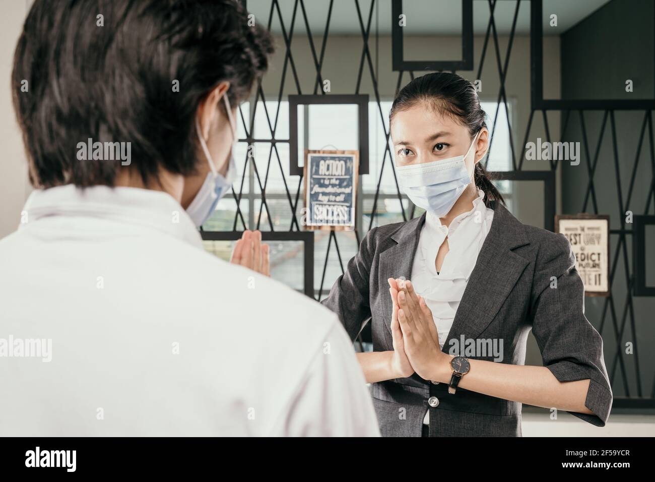 women greeting man guest using health mask to protect and keep social ...