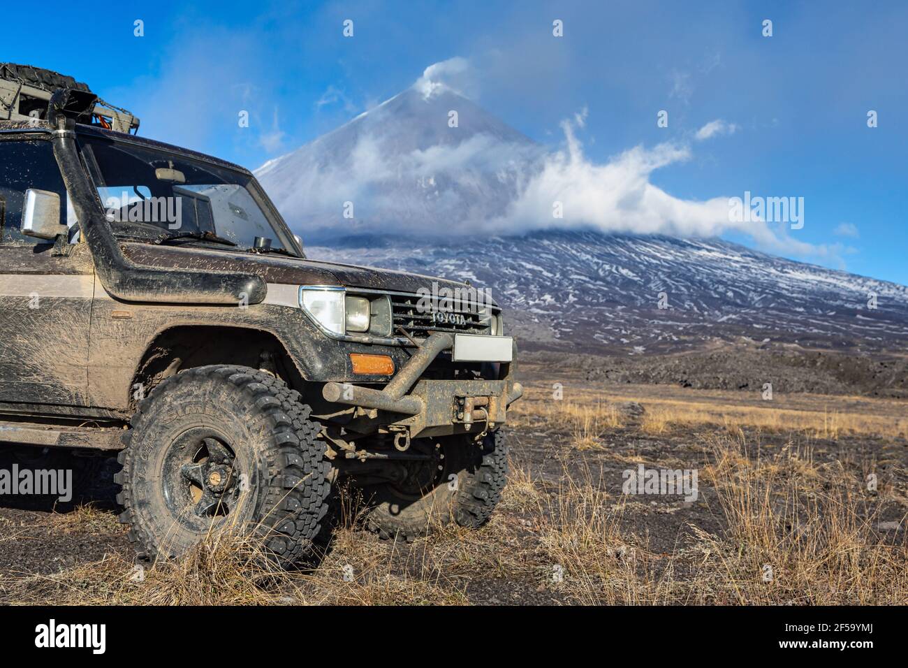 Japanese Toyota Land Cruiser Prado on mount on background eruption ...