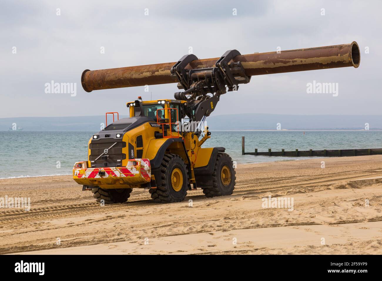 Volvo L180H Optishift Wheel Loader carrying big pipe along beach for ...