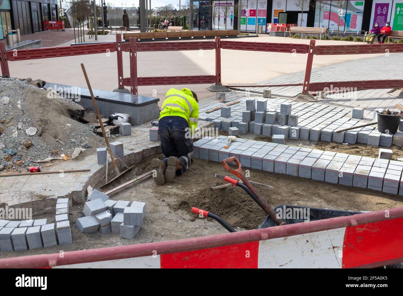 Workman laying block paving, ashford, kent, uk Stock Photo - Alamy