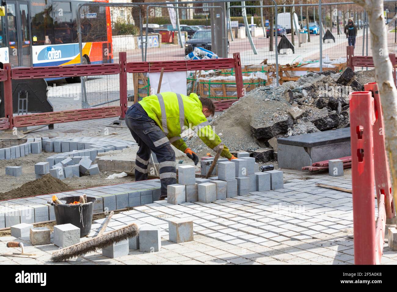 Workman laying block paving, ashford, kent, uk Stock Photo - Alamy