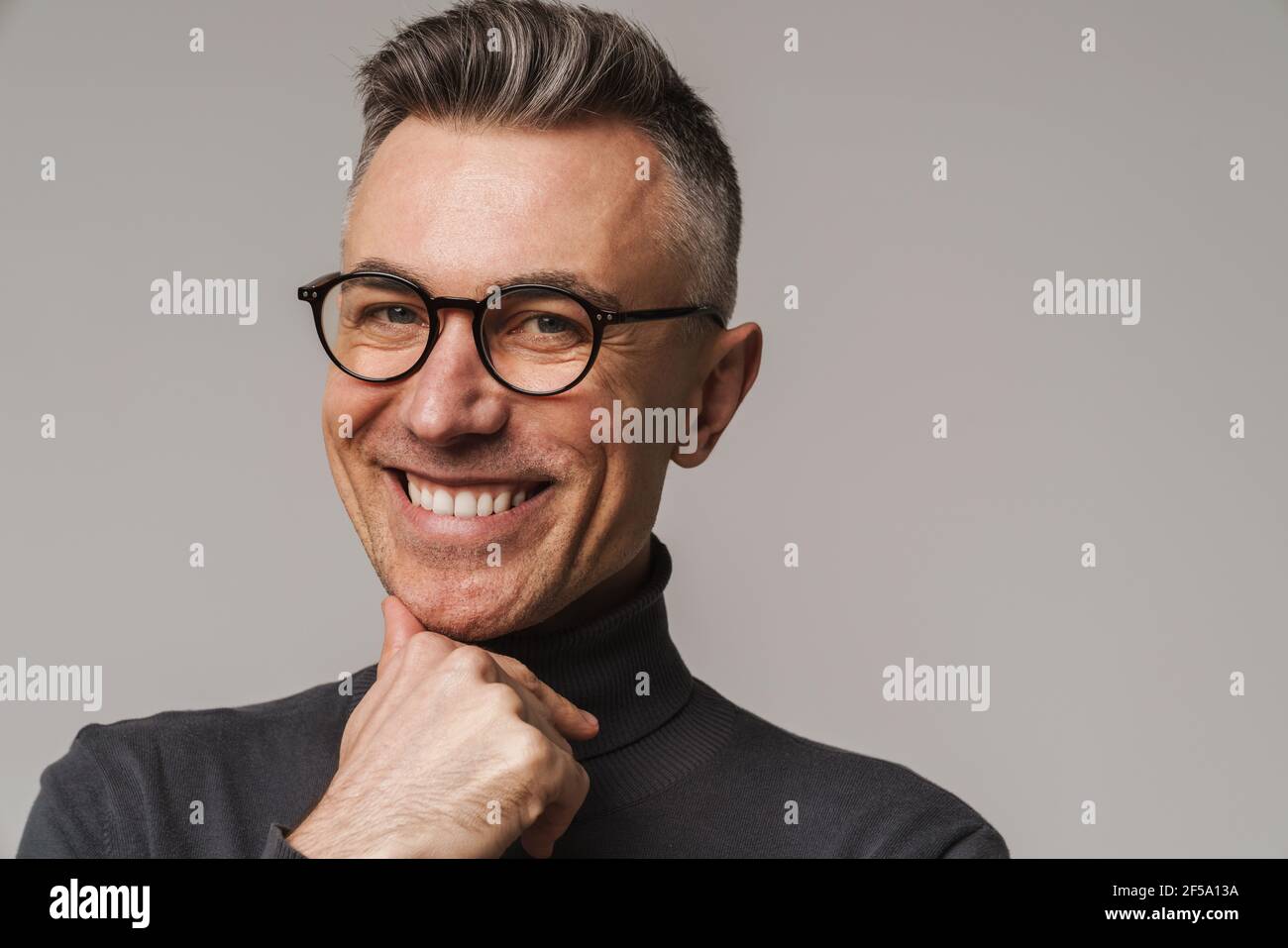 Handsome smiling confident smart looking man posing isolated over gray background Stock Photo ...