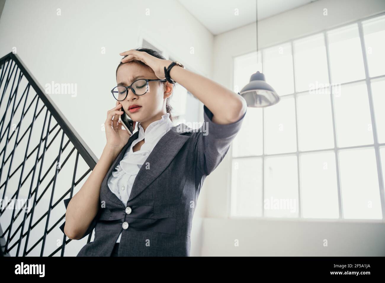 young beautiful businessman talking on the phone with a sad expression ...