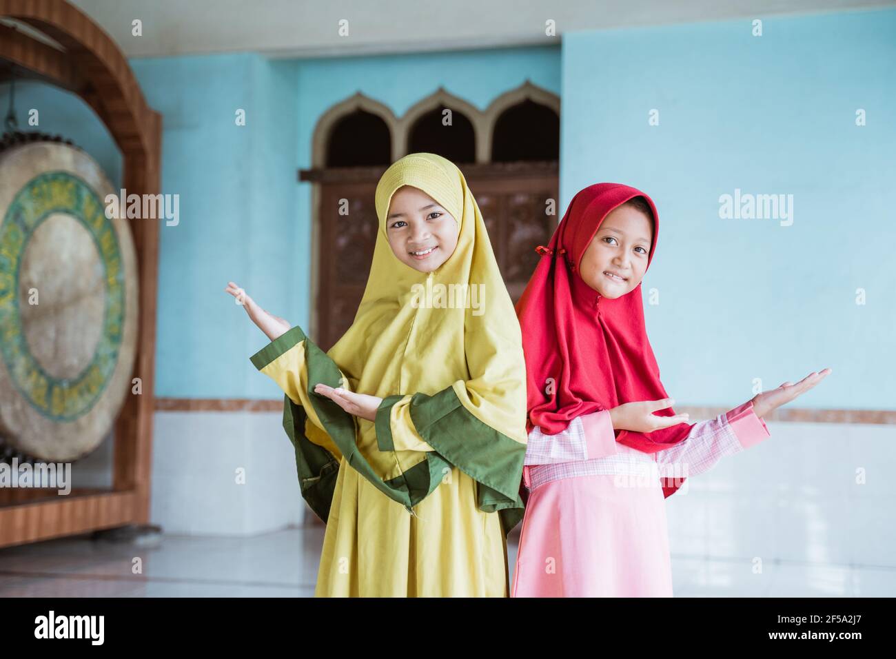 Two kid girl asian Muslim smiling showing something Stock Photo - Alamy