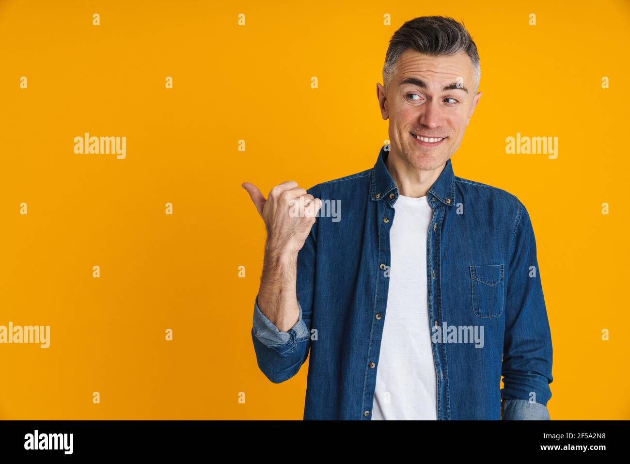 Happy handsome man smiling and pointing finger aside isolated over ...